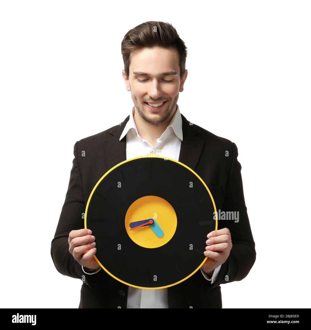 Man in black suit holding big clock on white background Stock Photo - Alamy