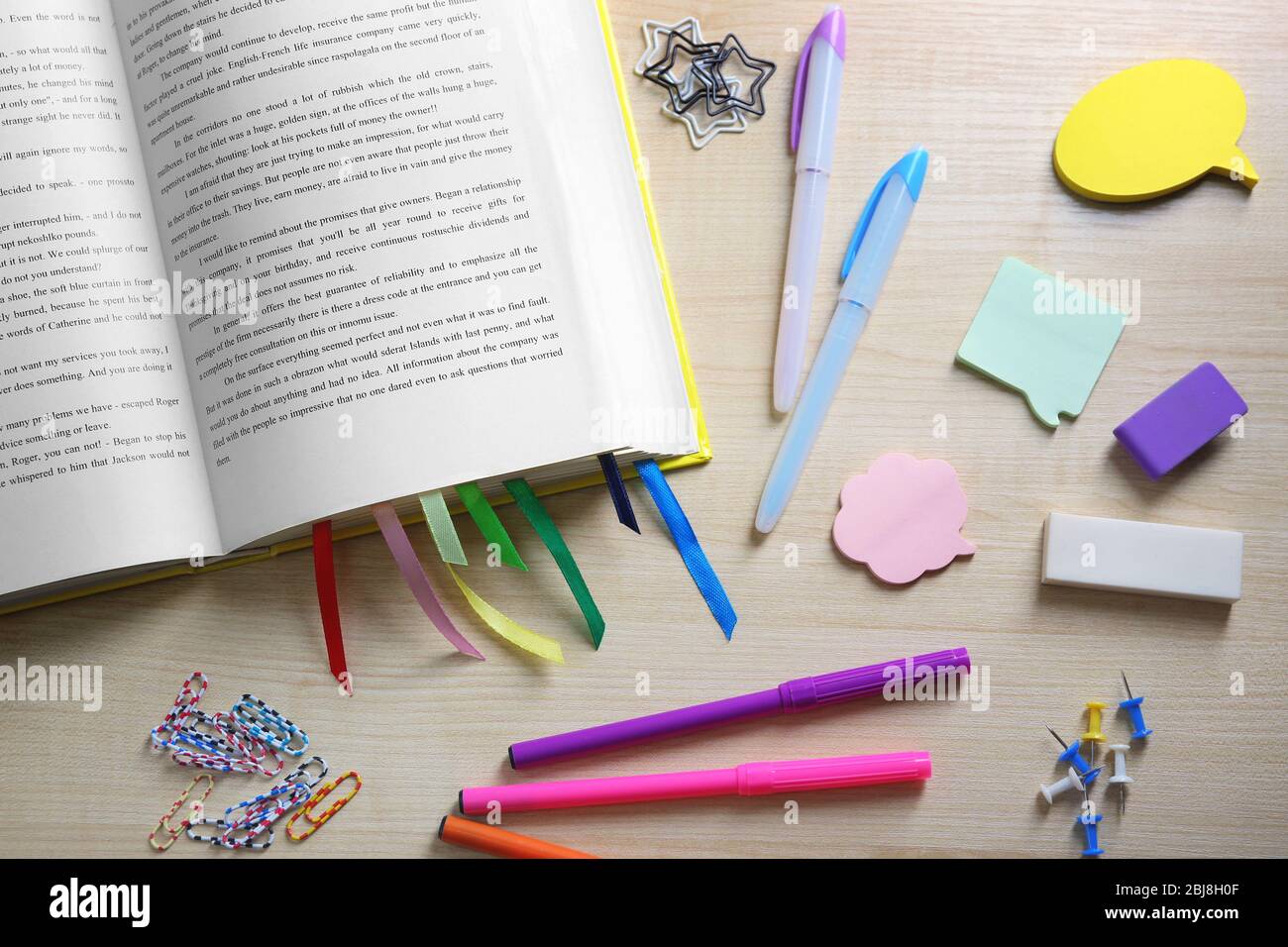 Open book with bookmarks on wooden table Stock Photo - Alamy