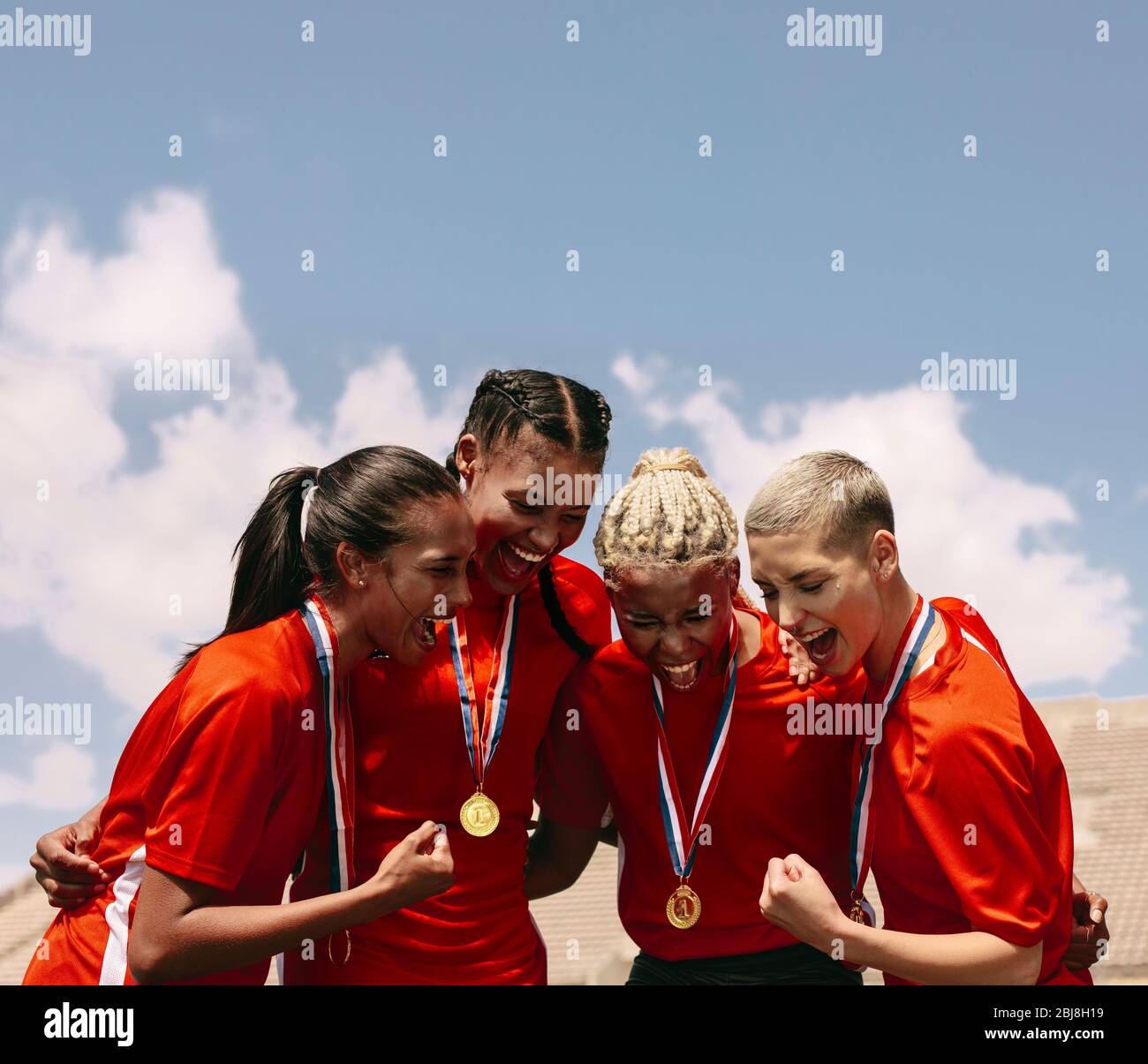 Excited female soccer players shouting in joy after winning the ...