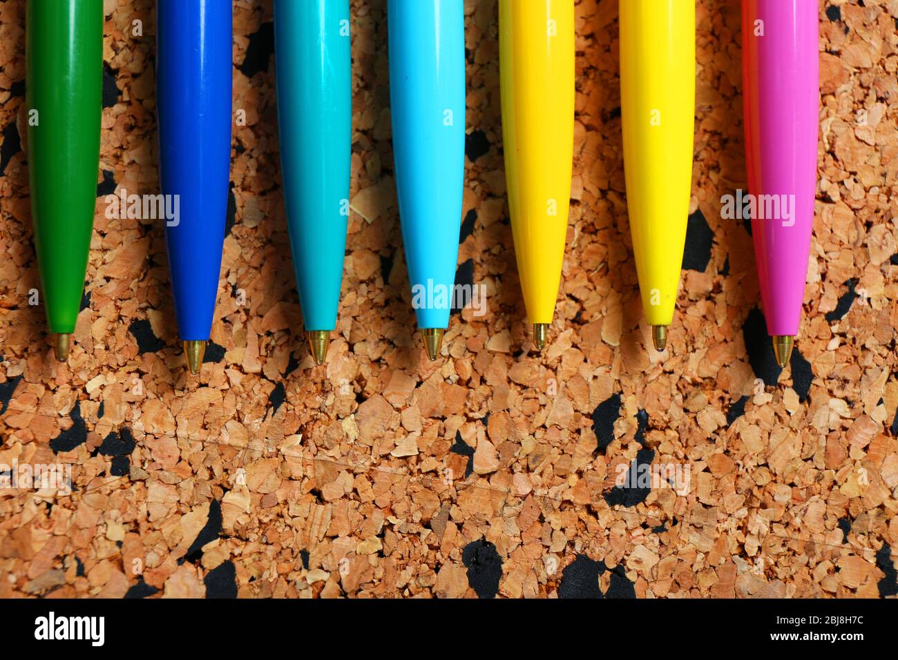Colour pens on cork board background Stock Photo - Alamy