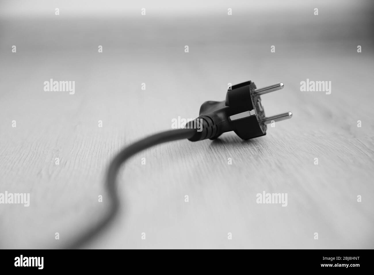Power plug over wooden floor background Stock Photo - Alamy