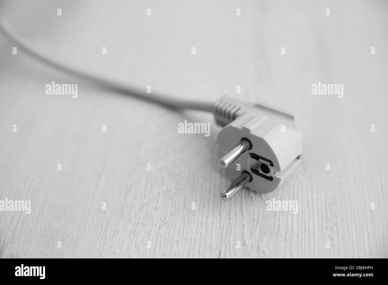 Power plug over wooden floor background Stock Photo - Alamy