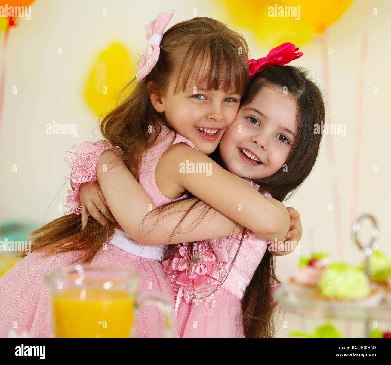 Happy little girls hugging at birthday party Stock Photo - Alamy