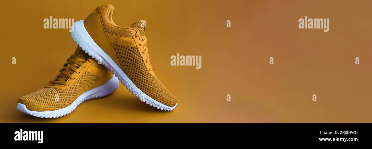 Colorful sport shoes on mustard color backround Stock Photo - Alamy