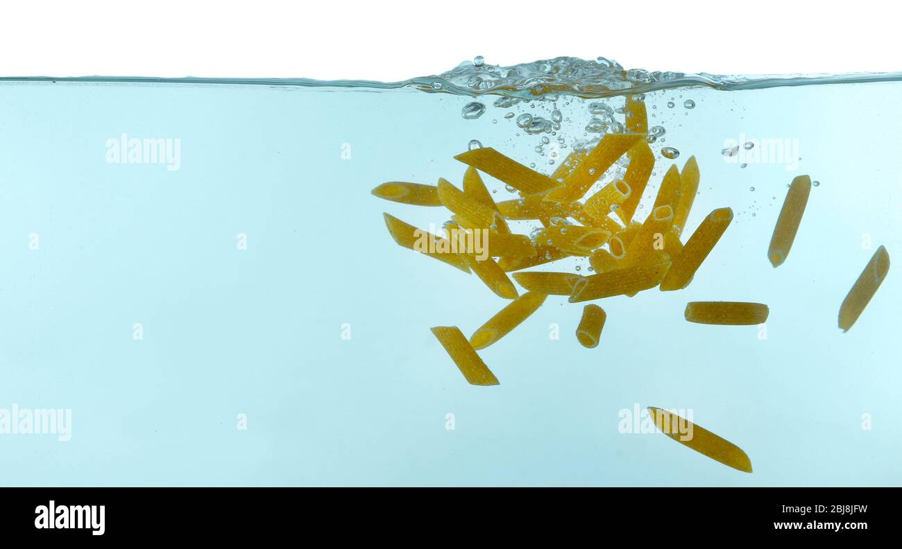 Penne pasta falling in water Stock Photo - Alamy
