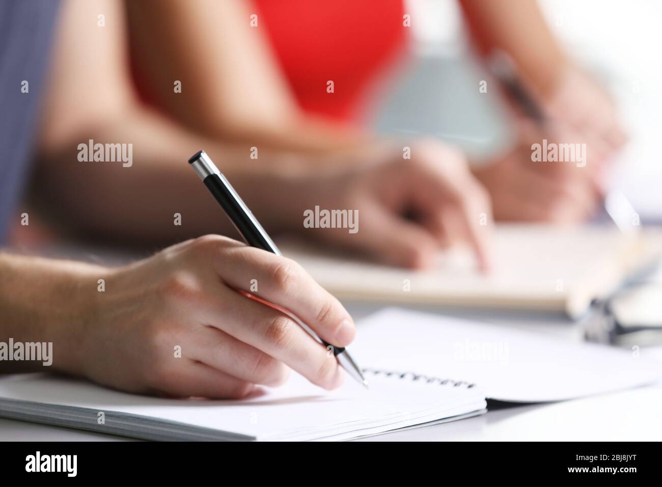 Student's hand writing in exercise book at the table Stock Photo - Alamy