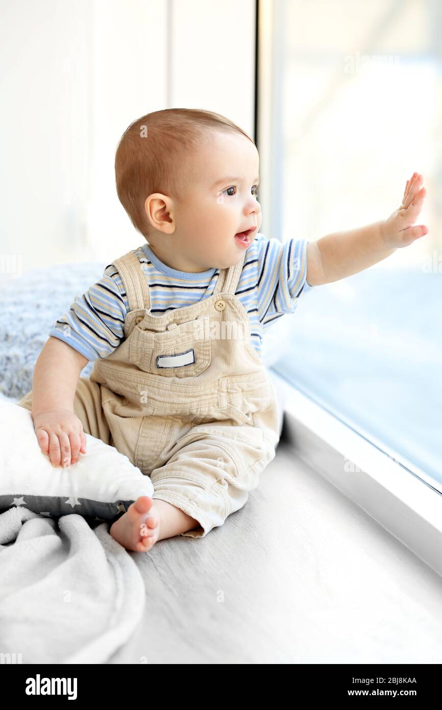 Little baby boy looking out the window at home Stock Photo - Alamy