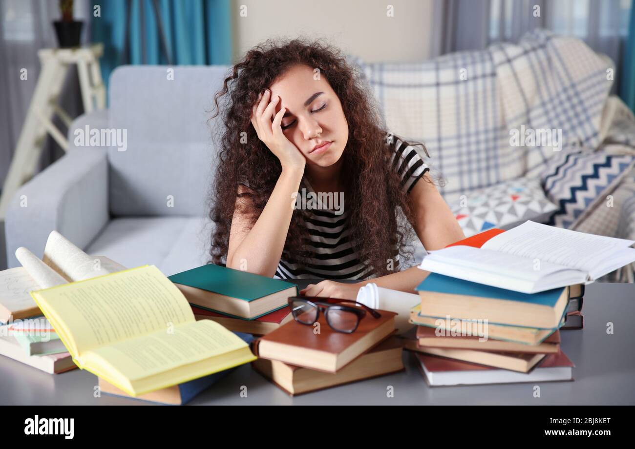 Tired student with books at home Stock Photo - Alamy