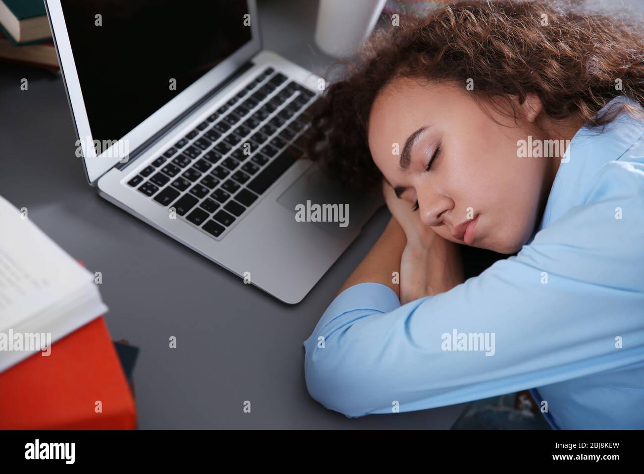 Tired beautiful girl sleeping on table Stock Photo - Alamy
