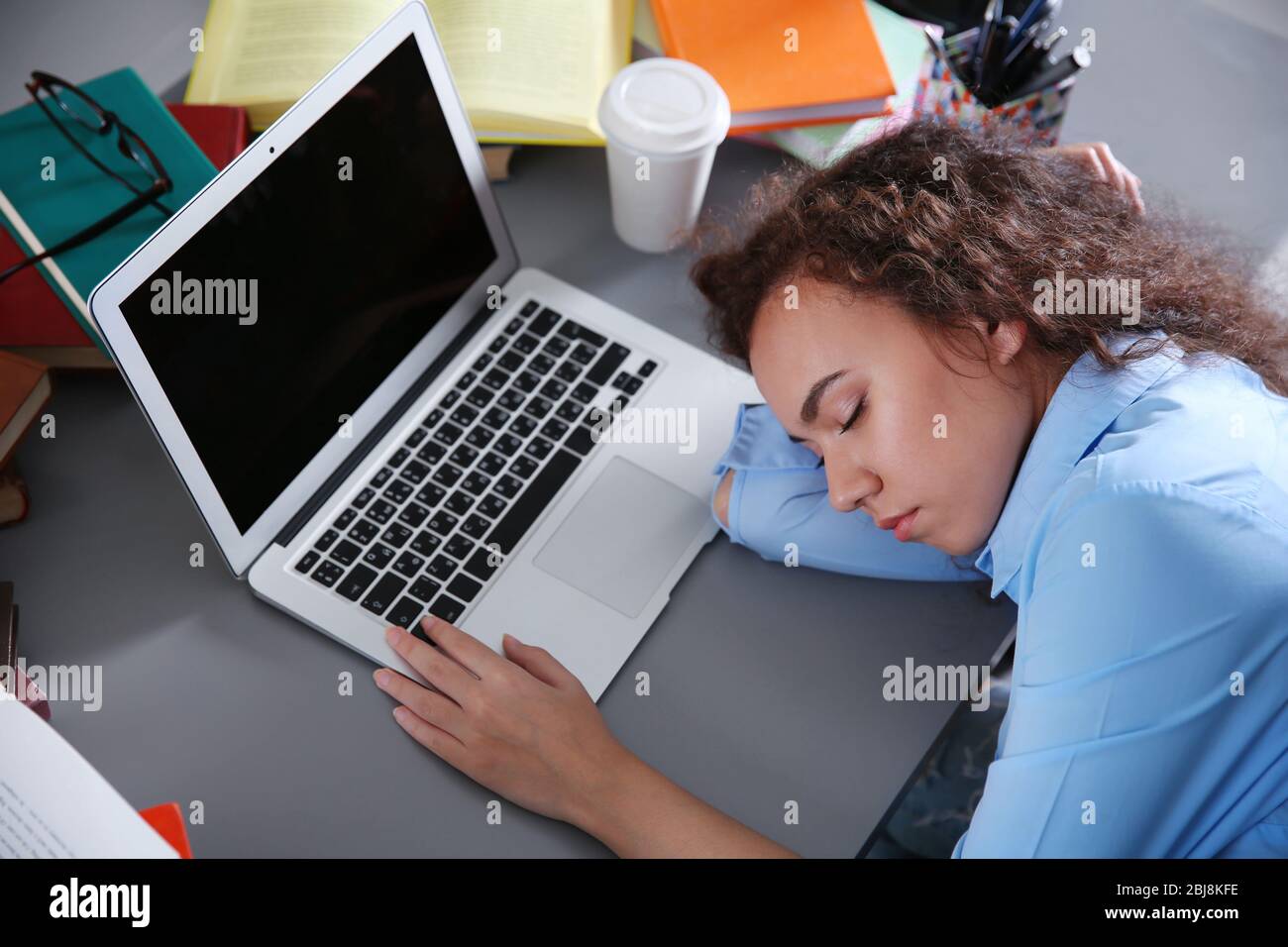 Tired beautiful girl sleeping on table Stock Photo - Alamy