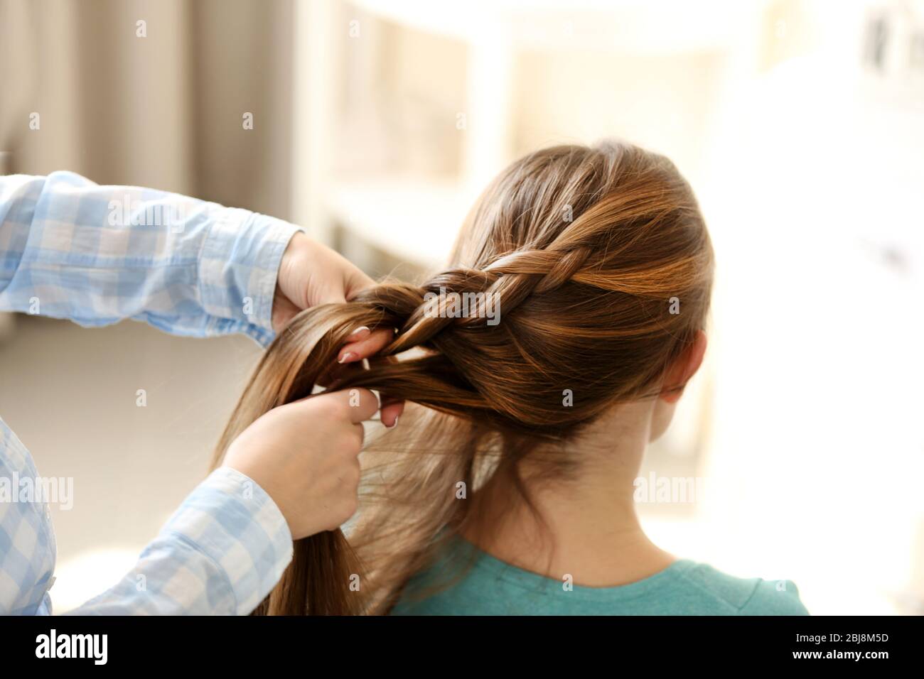Woman making braids Stock Photo - Alamy