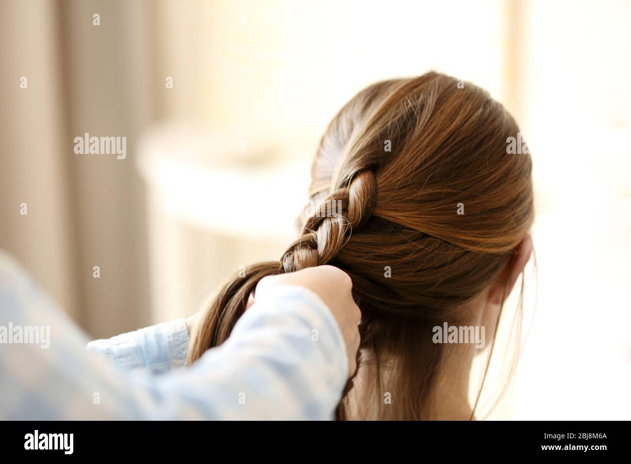 Woman making braids Stock Photo - Alamy