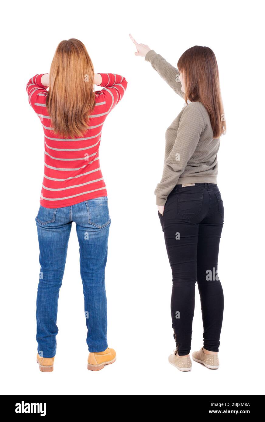 Back view of two pointing girl in sweater. Rear view people collection ...