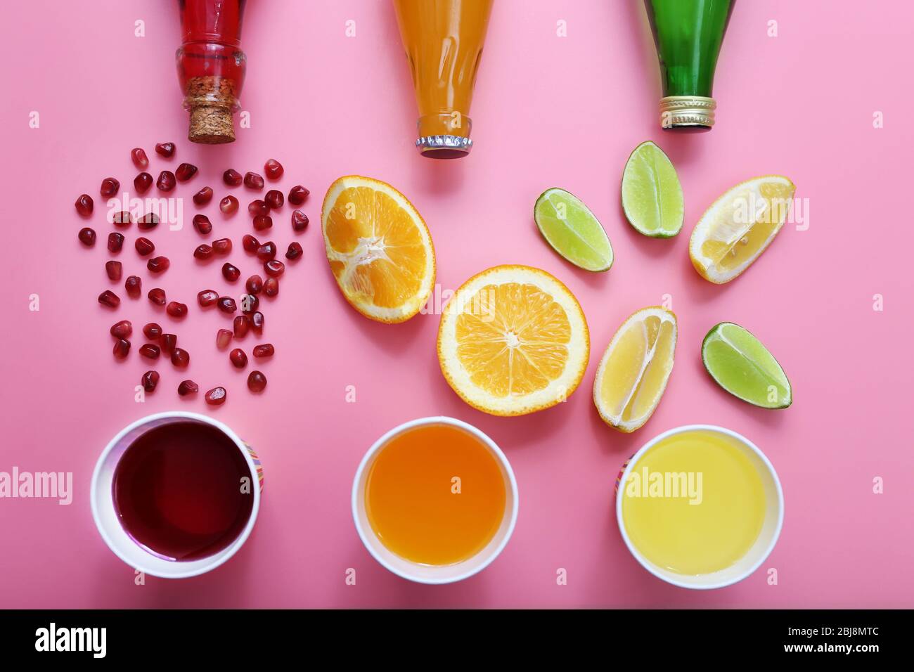 Different fruit drinks with fresh fruits on pink background Stock Photo ...