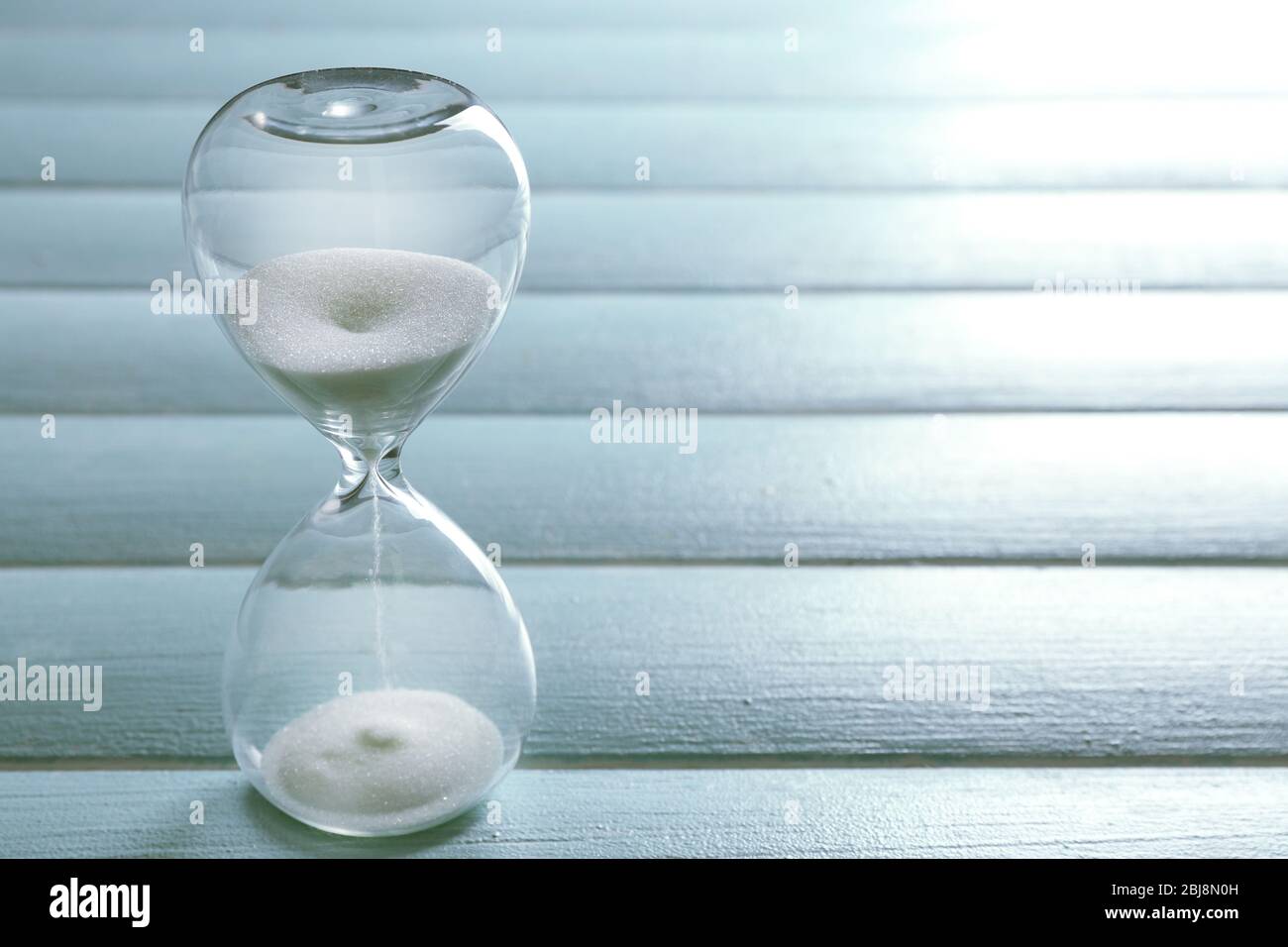 Hourglass on turquoise wooden background Stock Photo - Alamy