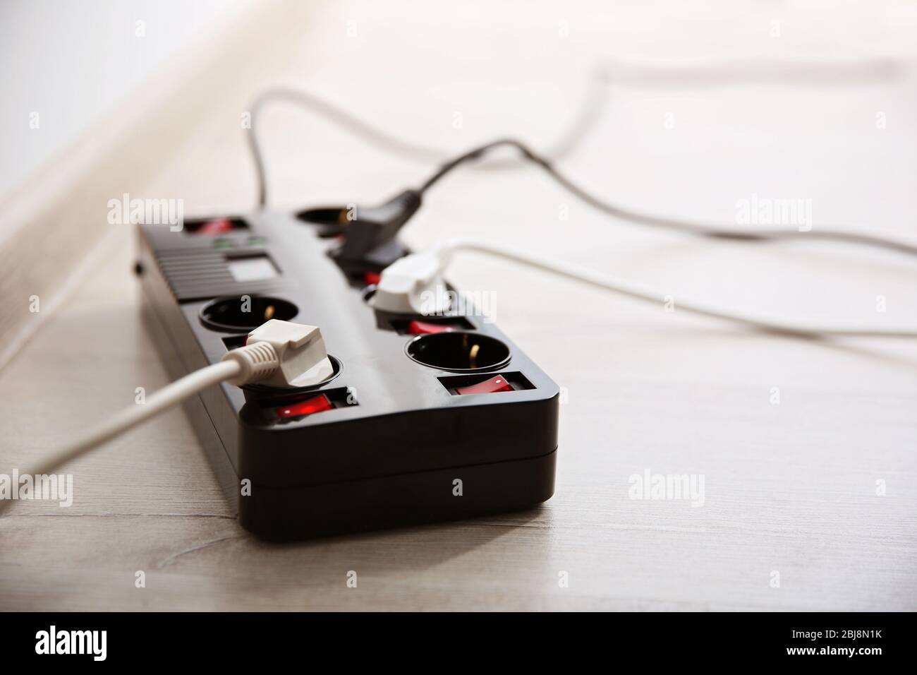 Overloaded power board on parquet, indoors Stock Photo - Alamy