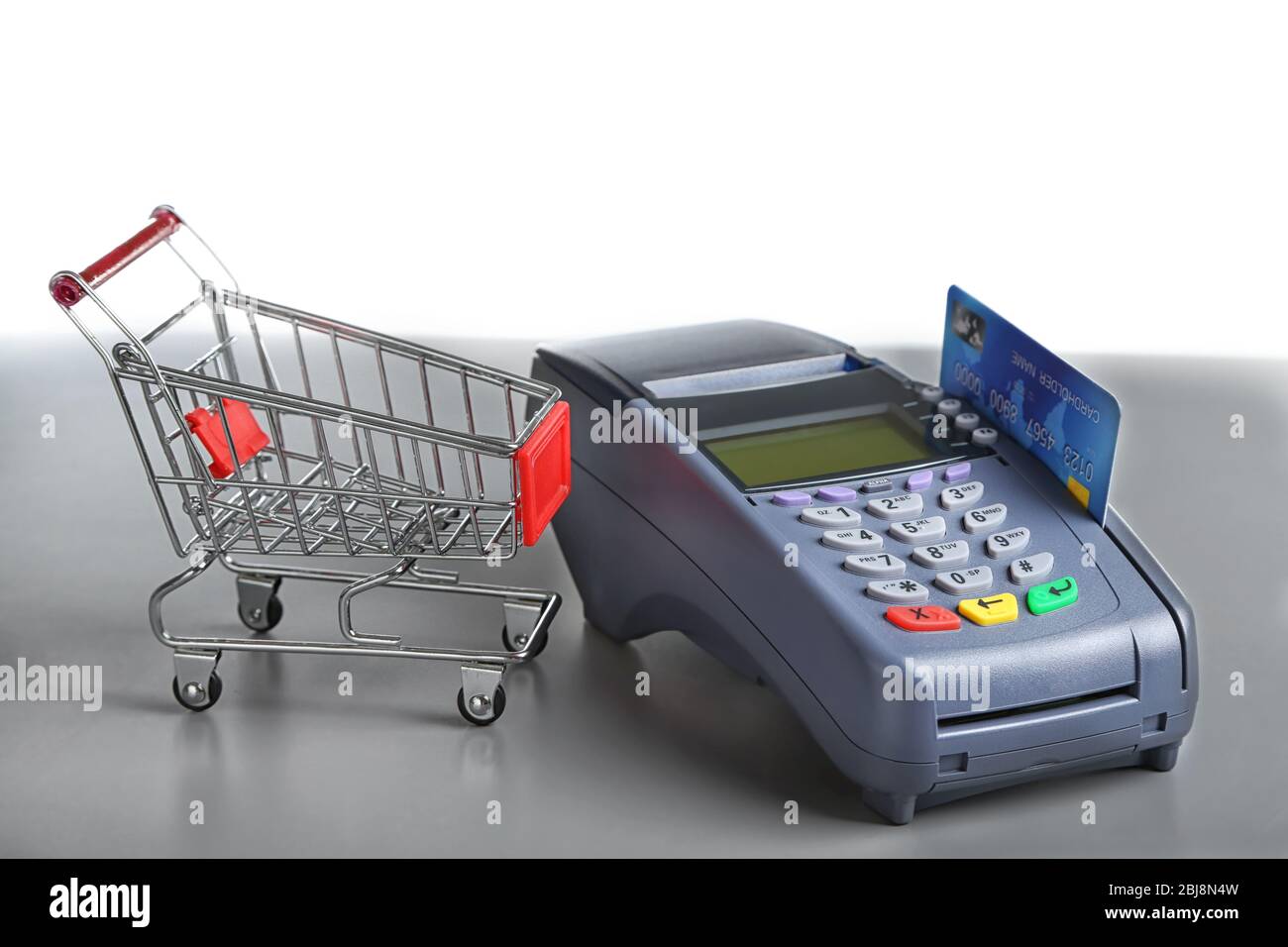 Payment terminal with supermarket trolley and credit card, isolated on ...