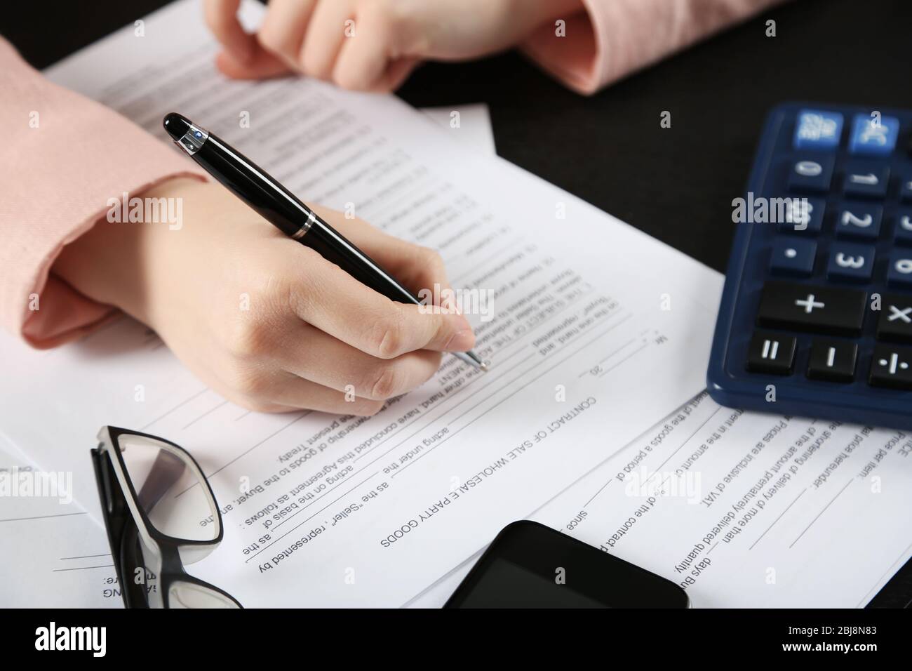 Female hand signing document at the desk closeup Stock Photo - Alamy