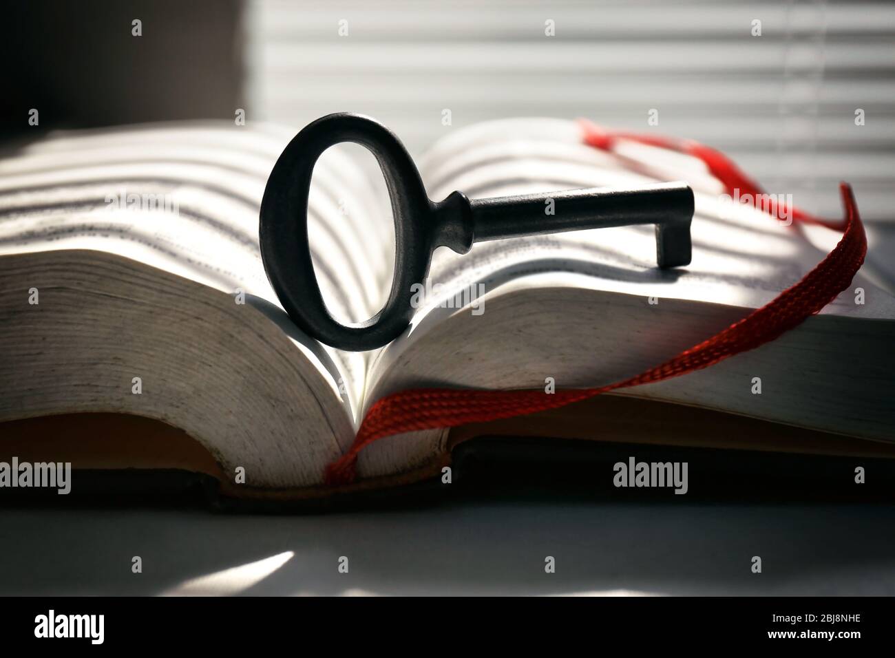 Vintage key with red rope bookmark on a light table Stock Photo - Alamy