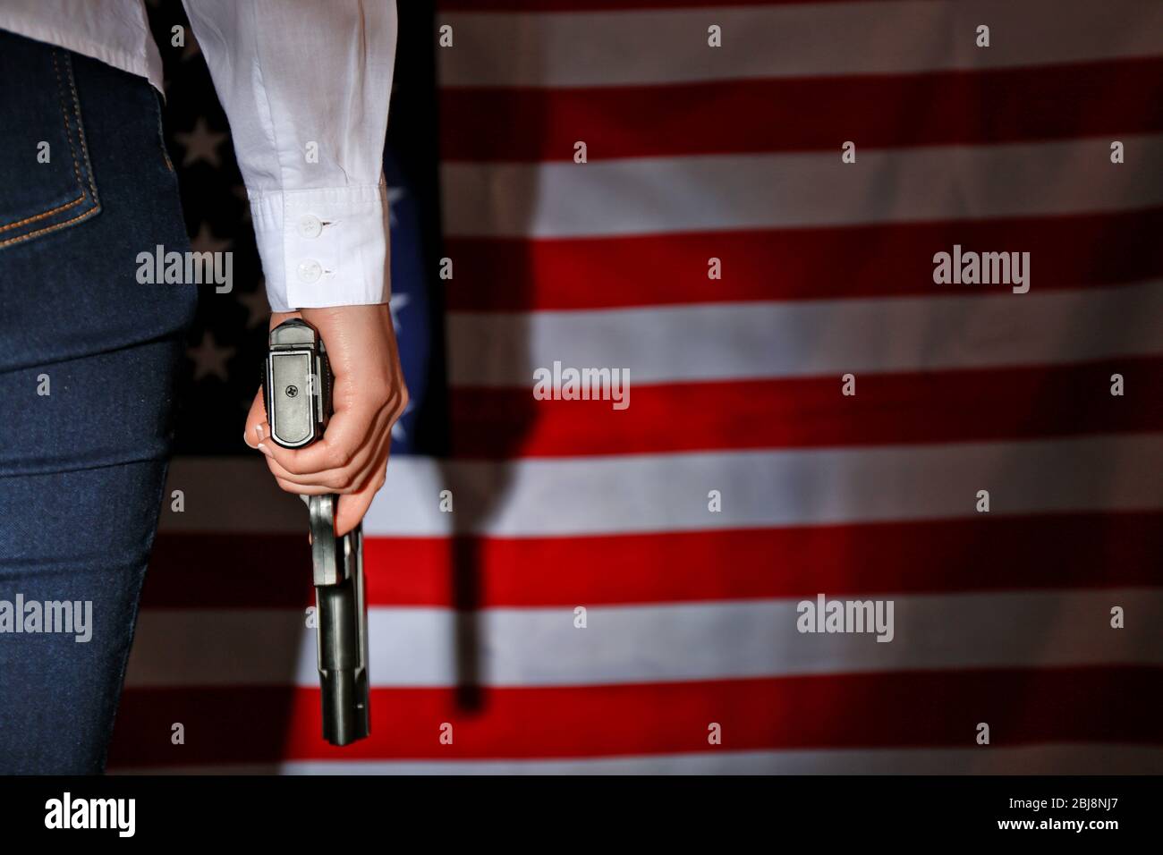 Woman holding handgun on USA national flag background Stock Photo - Alamy