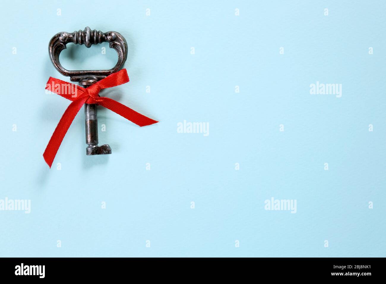 Vintage key with a red ribbon on a light blue background Stock Photo ...