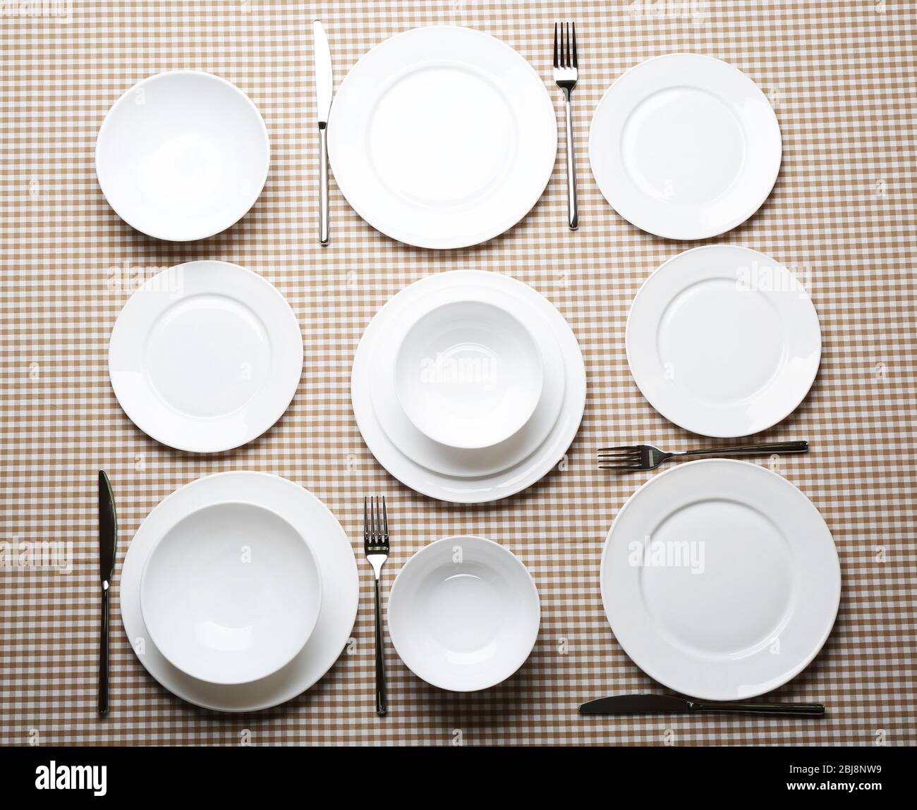 Set of white dishes on checkered background Stock Photo - Alamy