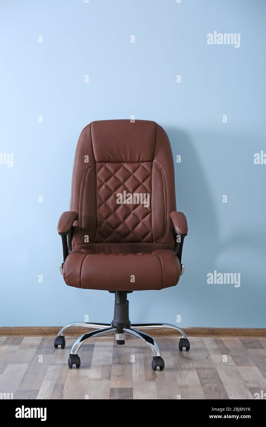 New office chair on wall background Stock Photo - Alamy