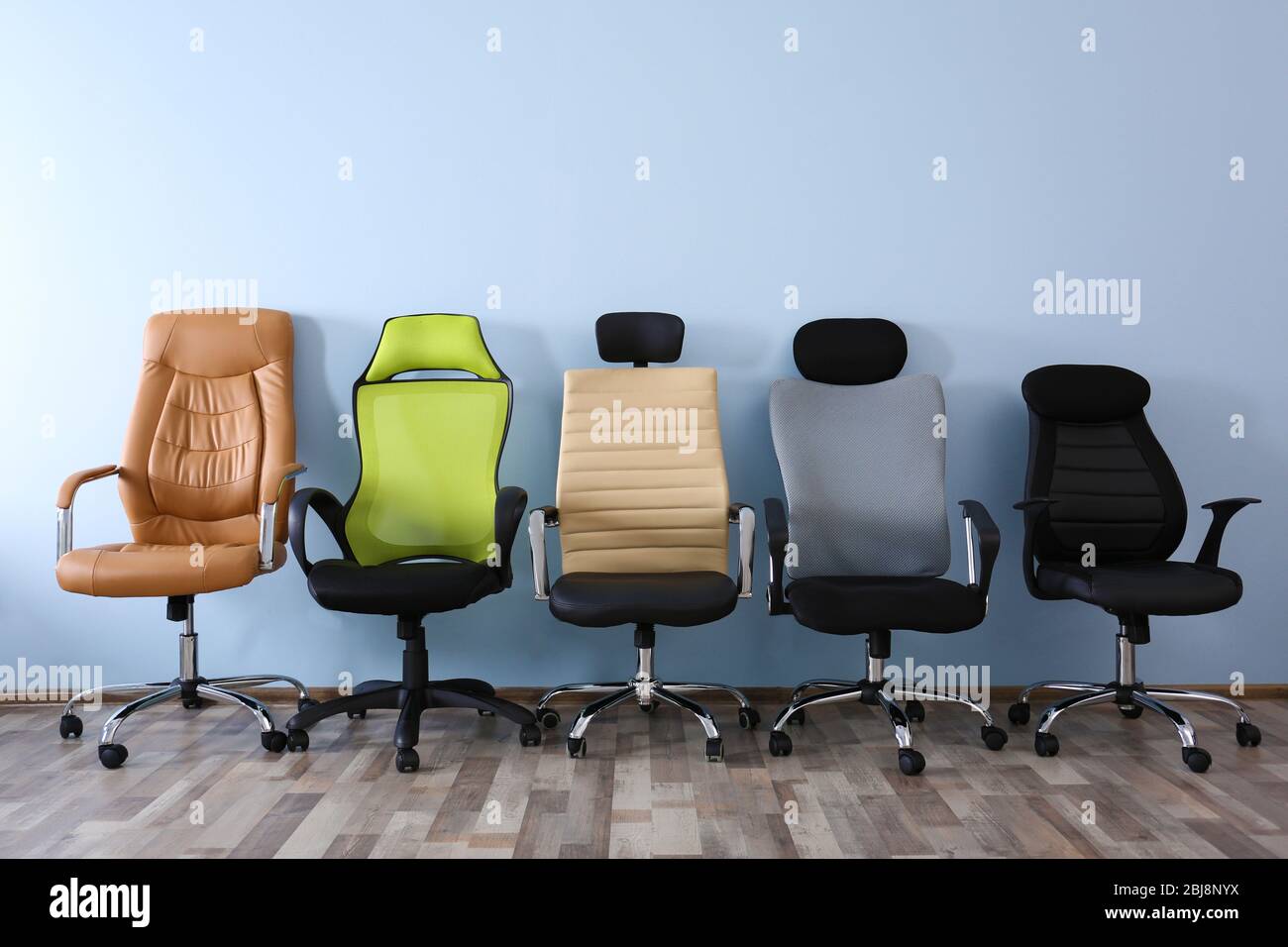 New office chairs on wall background Stock Photo - Alamy