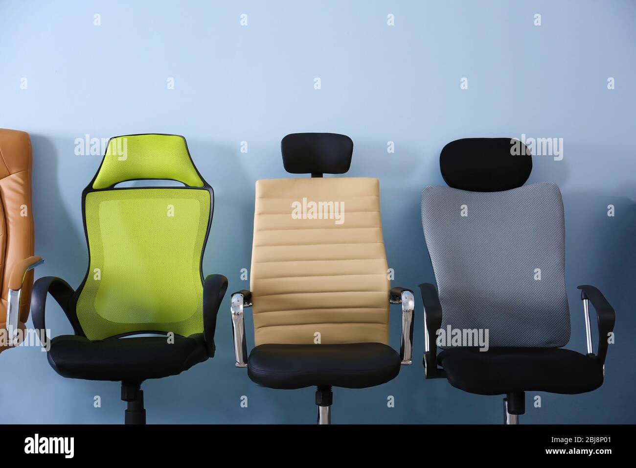 New office chairs on wall background Stock Photo - Alamy