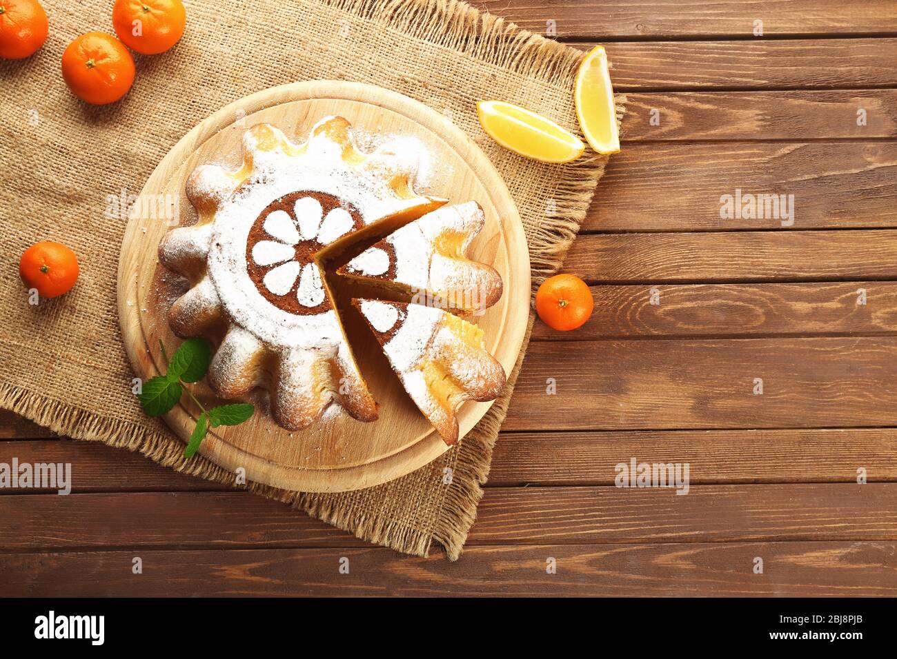 Delicious citrus cake with fruits on wooden board Stock Photo - Alamy