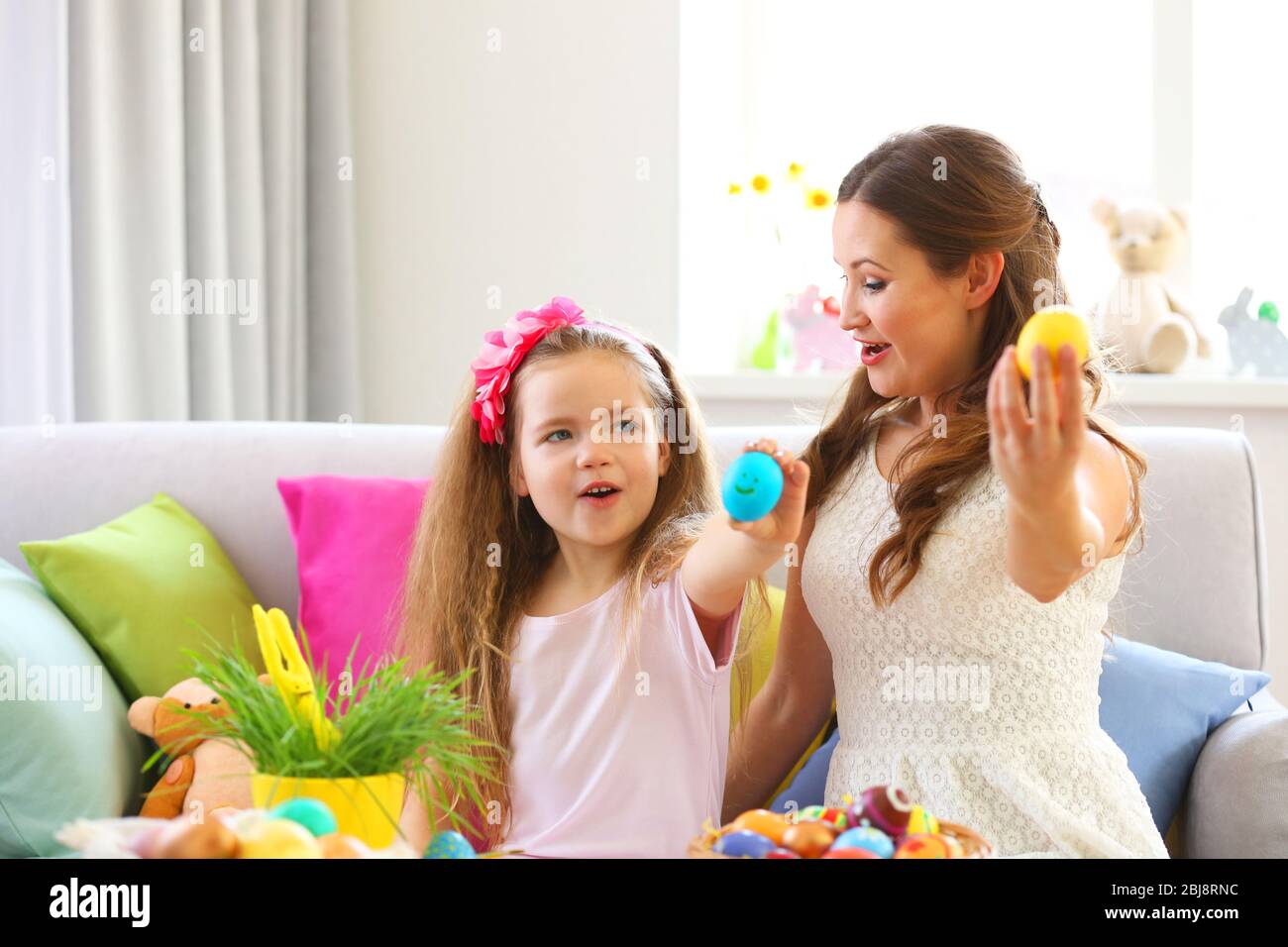 Mother and daughter holding Easter eggs, indoors Stock Photo - Alamy