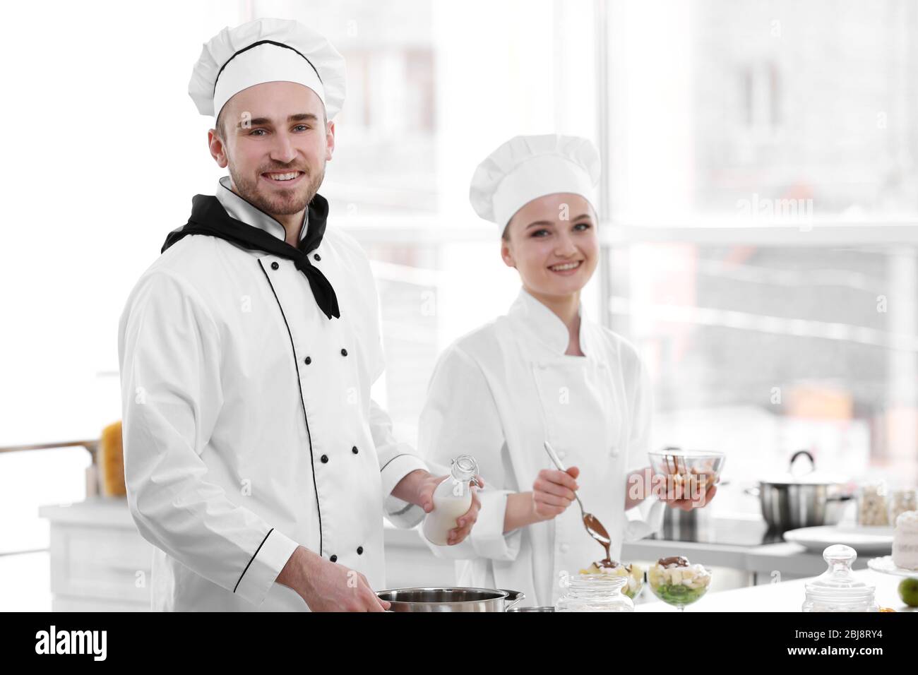 Male and female chefs working at kitchen Stock Photo - Alamy