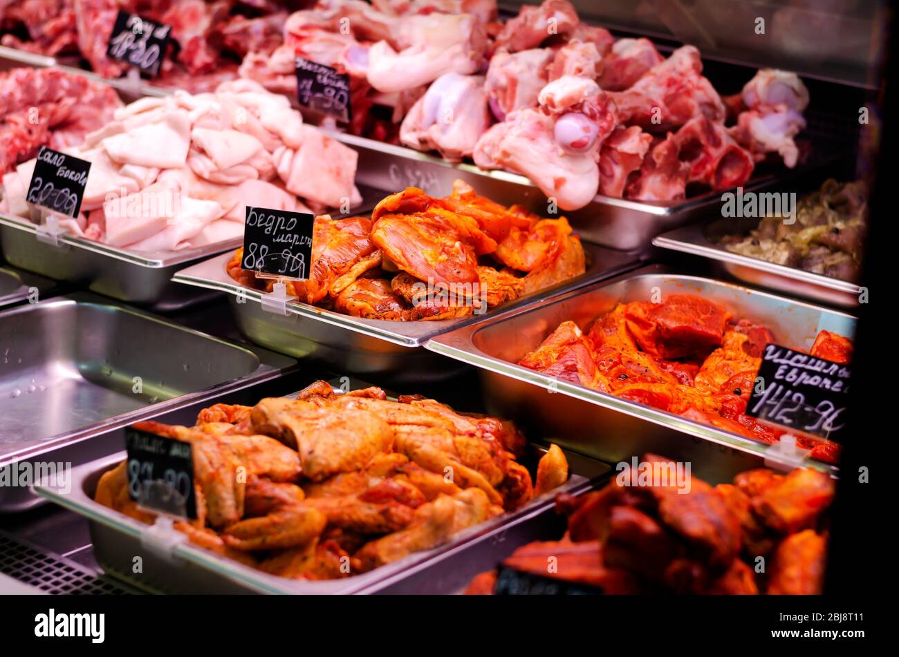 Variety of raw and pickled meat displayed in shop counter with price ...