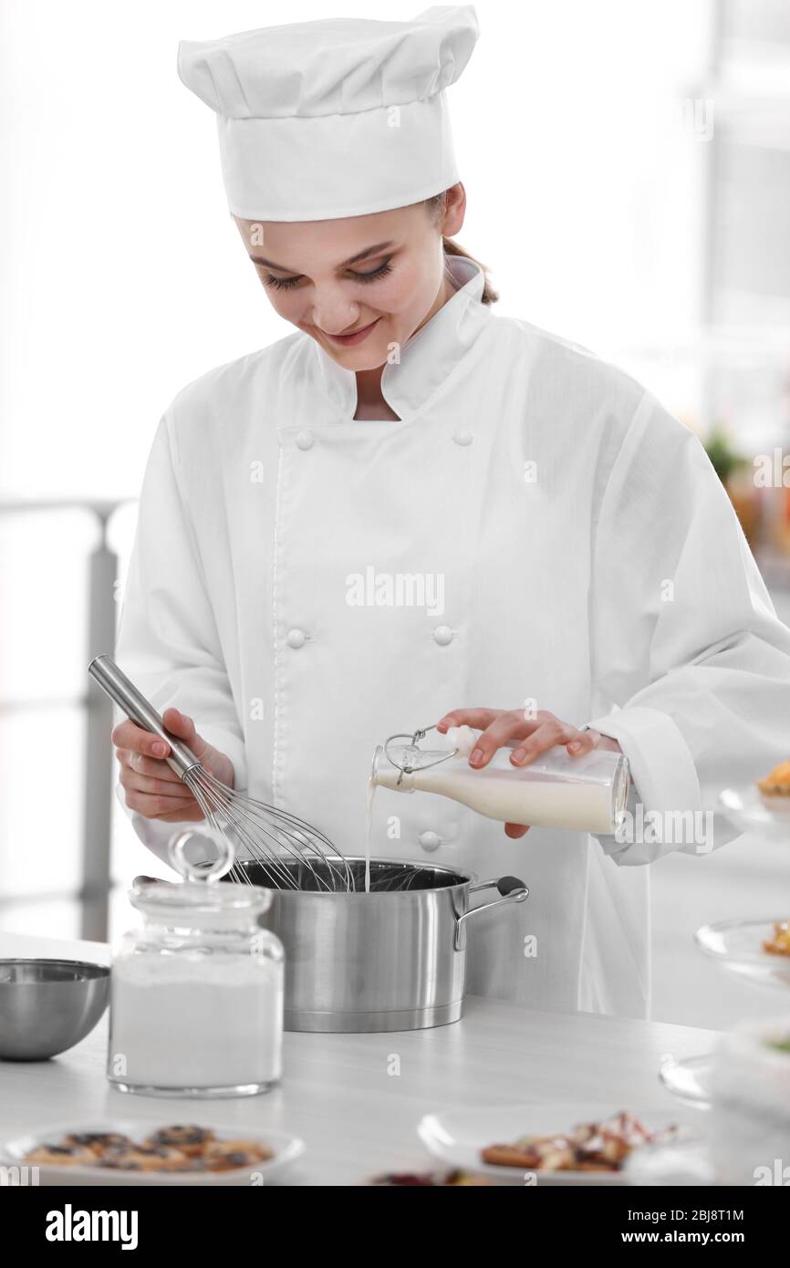 Caucasian female chef adding egg hi-res stock photography and images ...