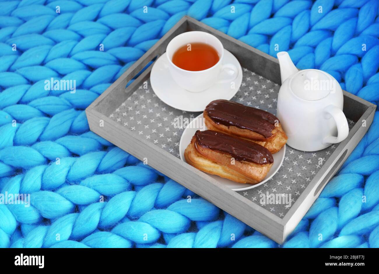 Cup of tea with pastry on knitted plaid background Stock Photo - Alamy