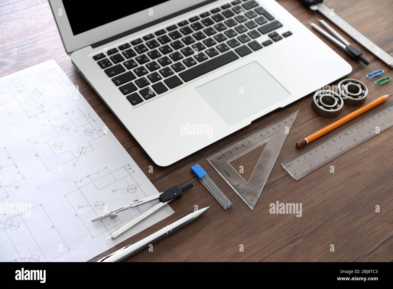 Laptop, engineering drawings and tools on wooden background Stock Photo ...
