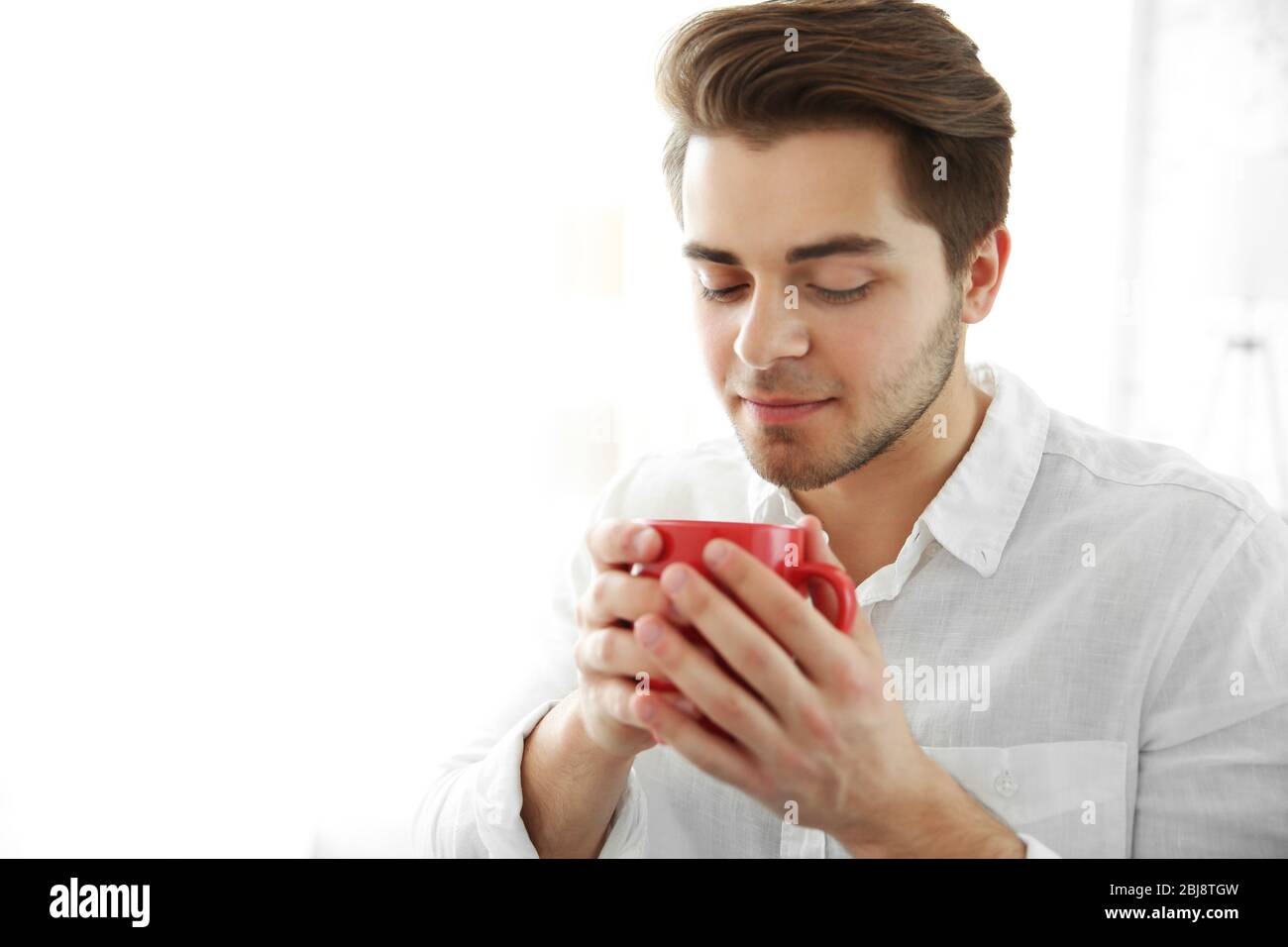 Handsome man drinking coffee on white background Stock Photo - Alamy