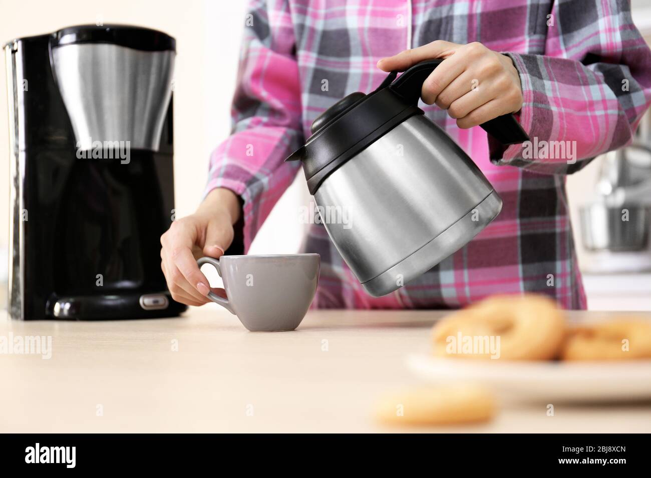 Woman pouring tea in kitchen Stock Photo - Alamy