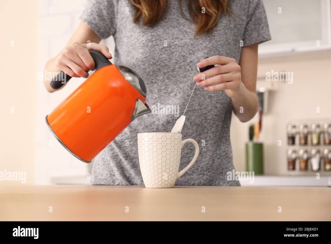 Woman pouring tea in kitchen Stock Photo - Alamy