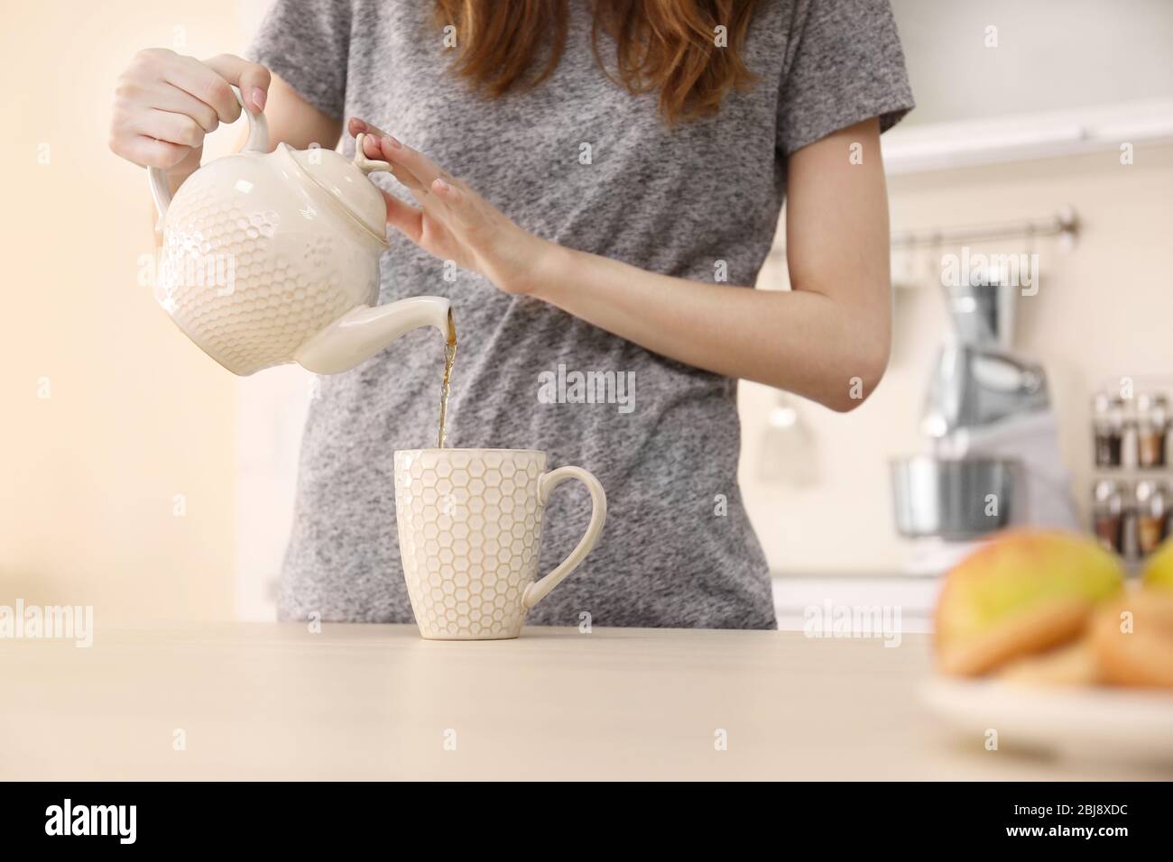 Woman pouring tea in kitchen Stock Photo - Alamy