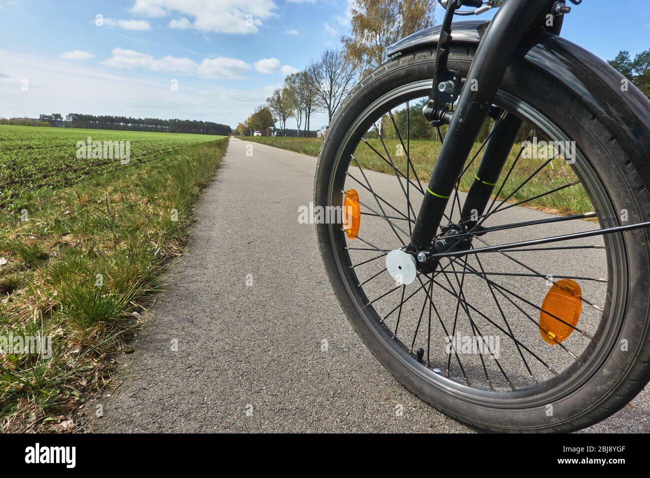 Front wheel of a bicycle on a paved bicycle path, which disappears next ...