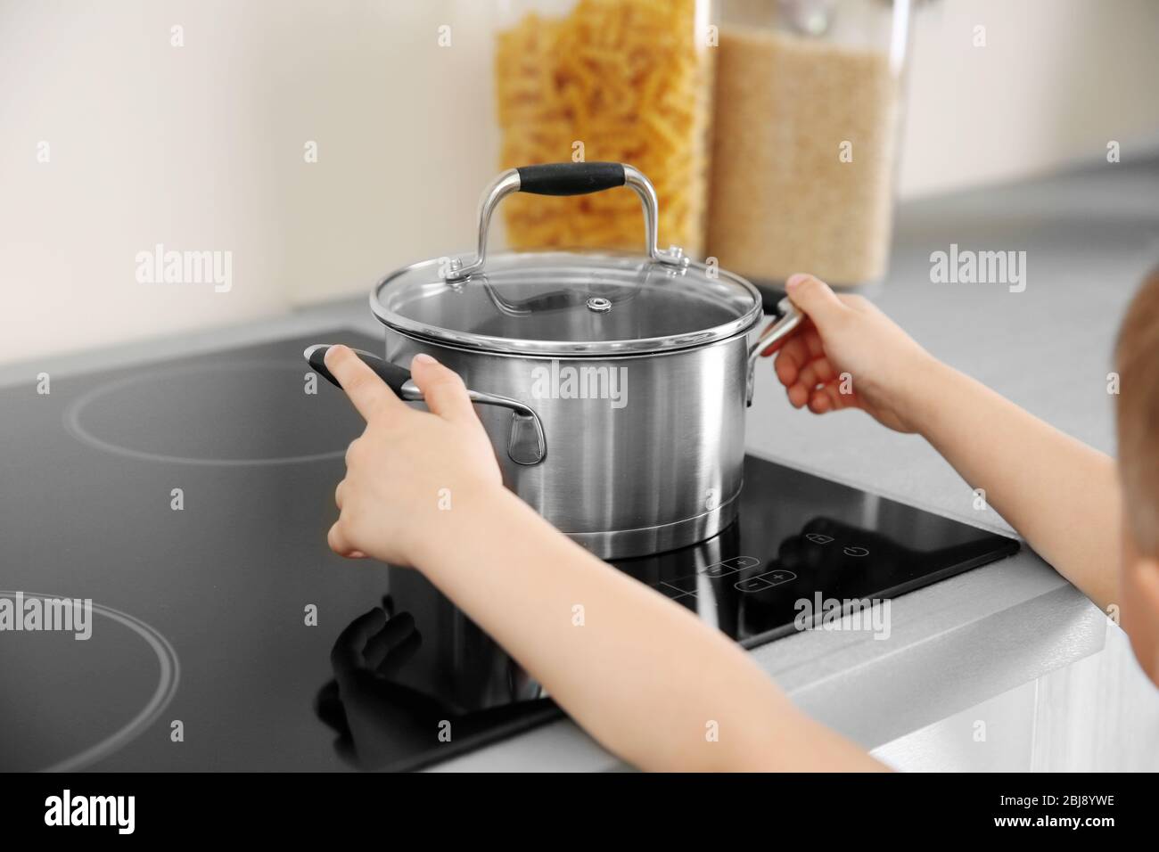 Little child playing with pan and electric stove in the kitchen Stock ...