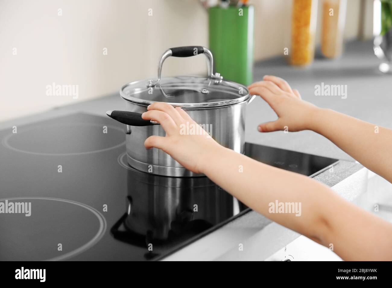 Little child playing with pan and electric stove in the kitchen Stock ...