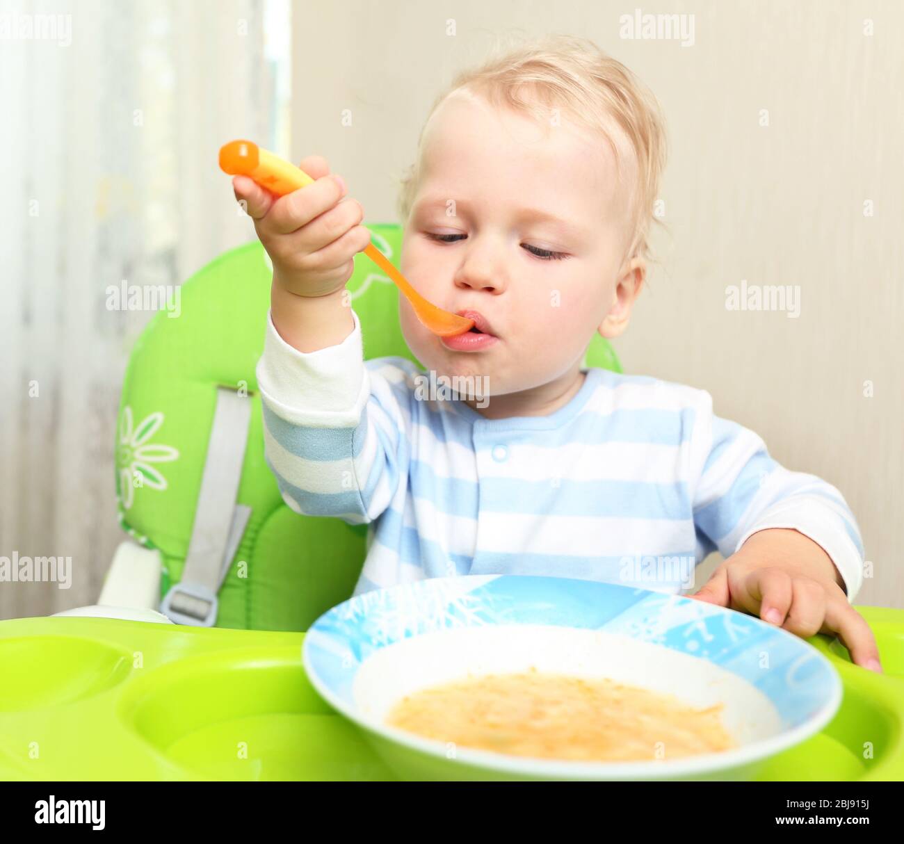 Cute little child eating blended carrot Stock Photo - Alamy