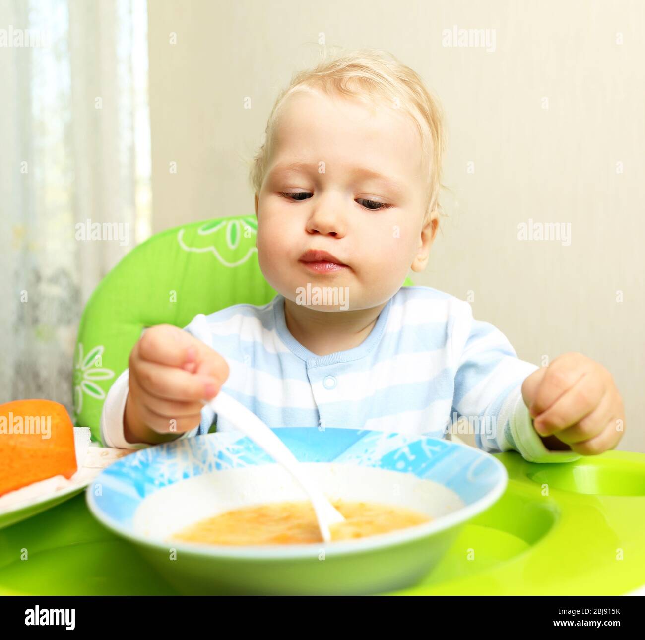 Cute little child eating blended carrot Stock Photo - Alamy