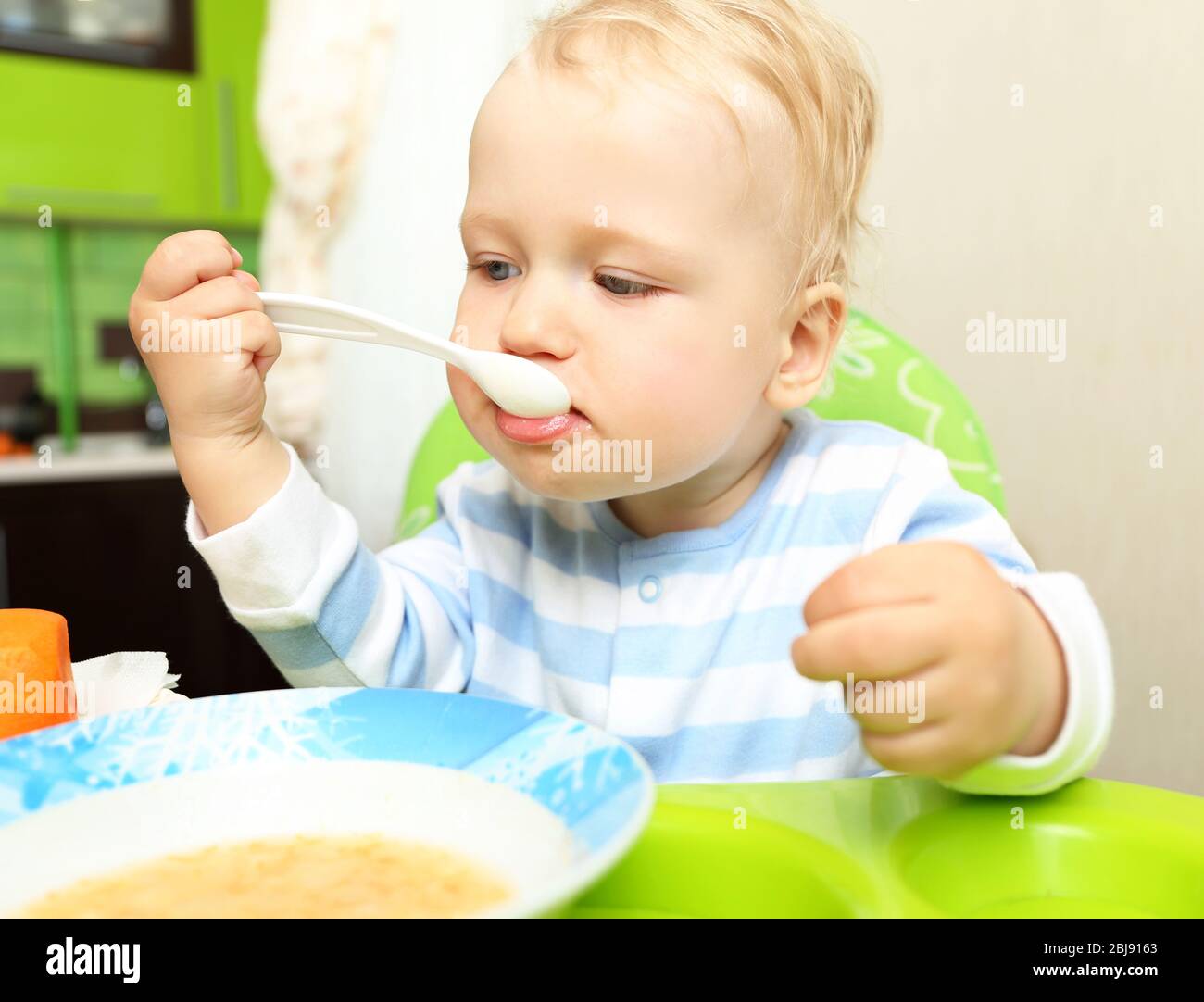 Cute little child eating blended carrot Stock Photo - Alamy