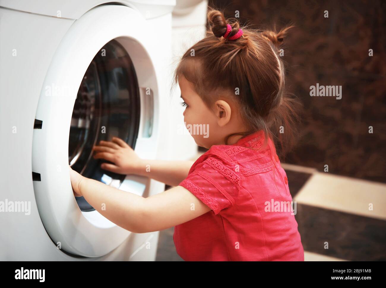 Little girl playing with washing machine Stock Photo - Alamy