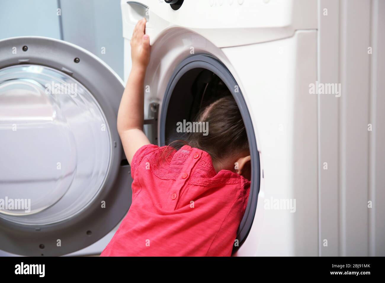Little girl playing with washing machine Stock Photo - Alamy