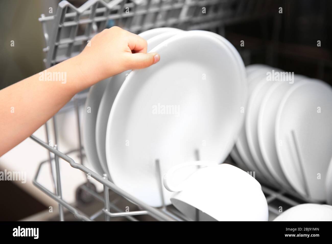 Little girl taking plates from the dishwasher, closeup Stock Photo - Alamy