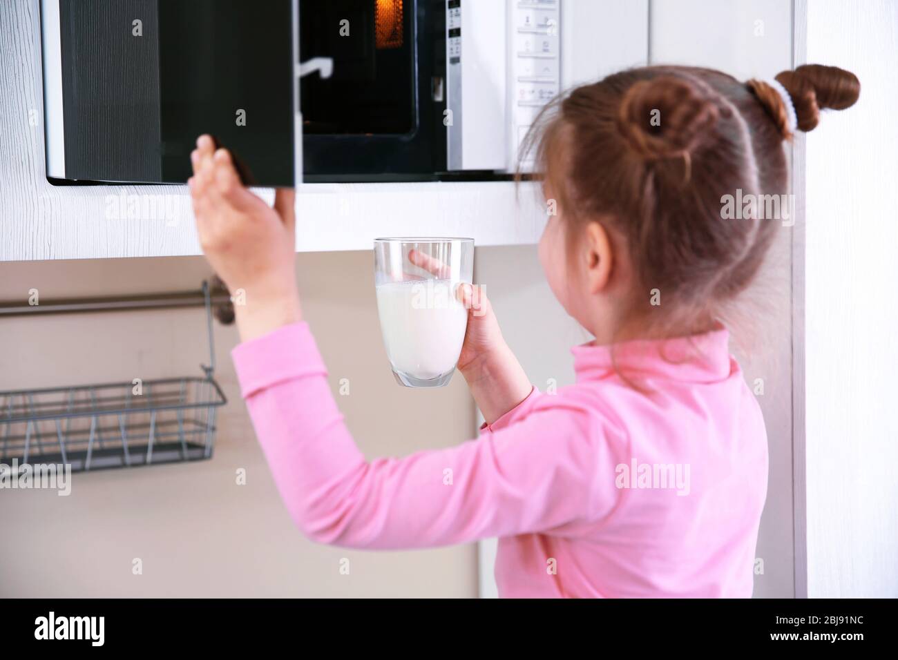 Little girl using a microwave oven Stock Photo - Alamy